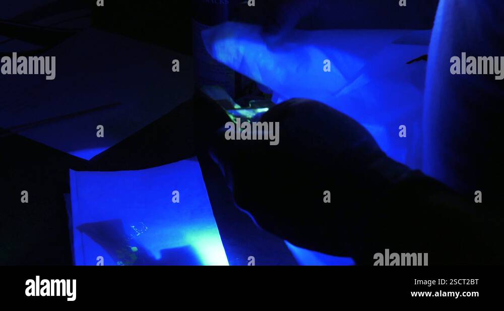 Engineer examines part under ultraviolet light during non-destructive ...