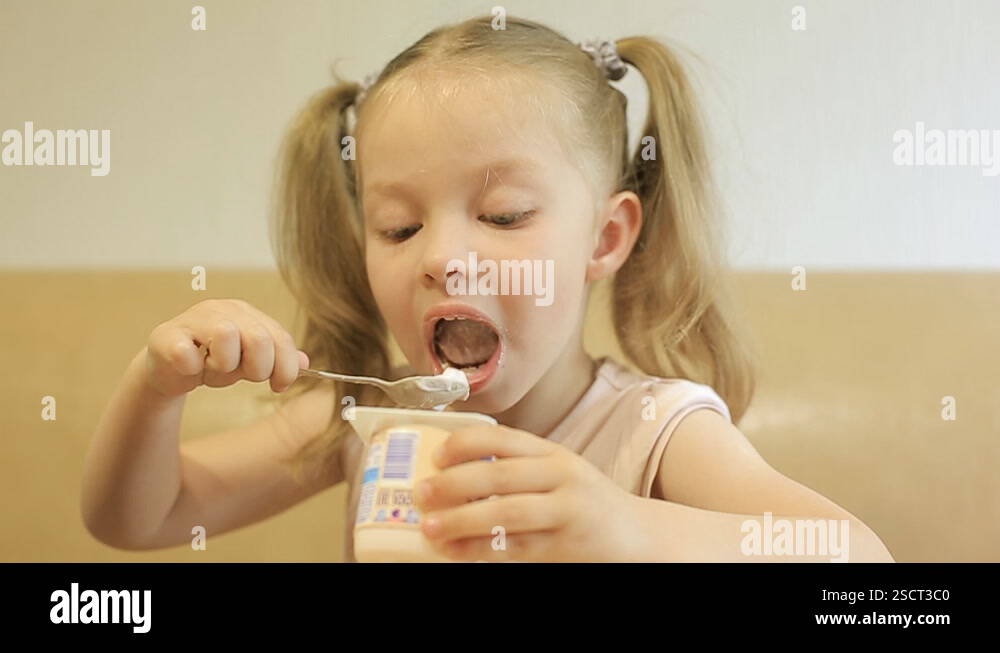 little girl with pigtails eating yogurt, useful dairy products for baby ...