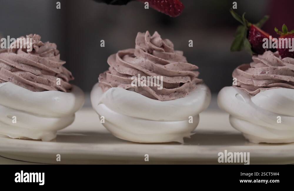 Decorating cake with strawberry. Butter cream on tasty desserts of ...