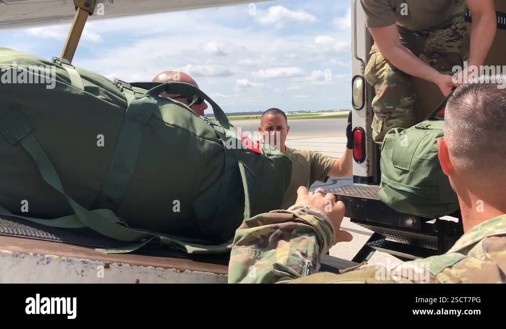 Soldiers load luggage from truck onto conveyor belt for deployment ...