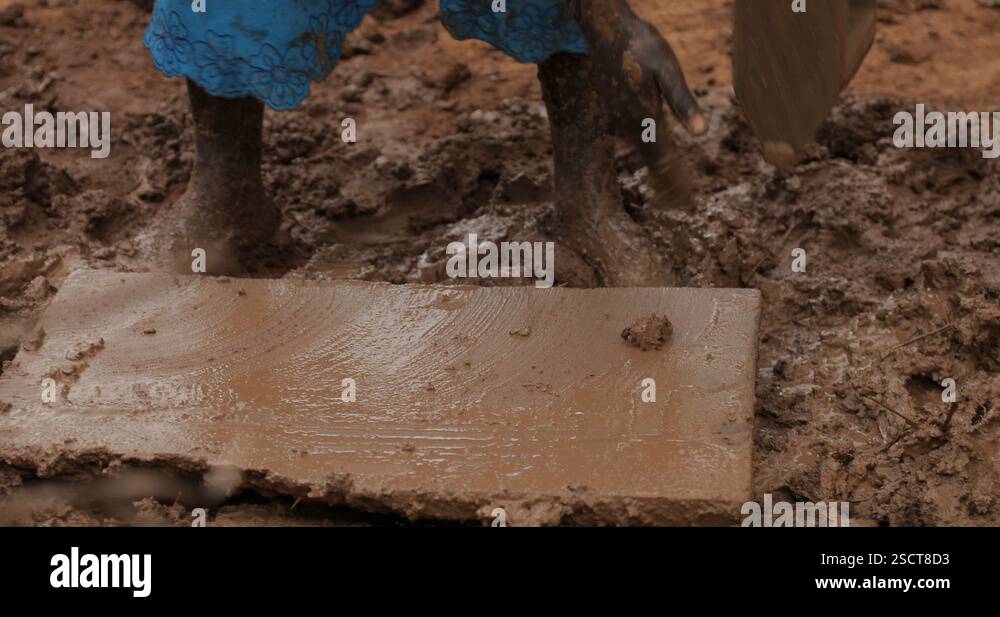 Women make Bricks from adobe pressing wet mud mixture into timber frame ...