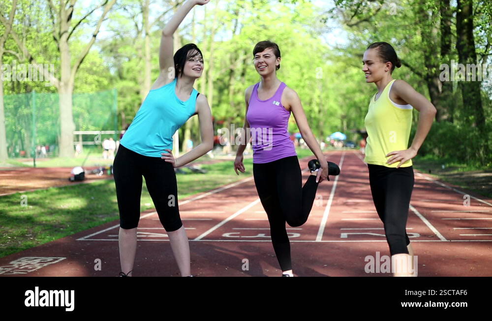 Young attractive woman stretching, exercising in the park, dolly shot ...