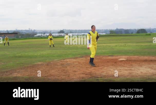 Multiracial female baseball players, catching and throwing the ball ...