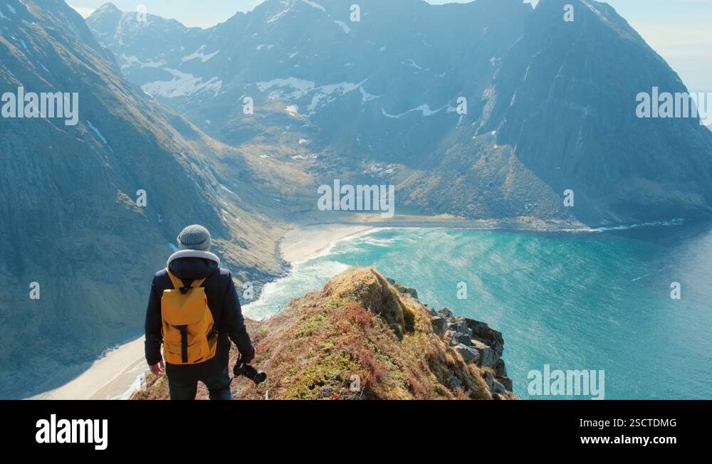 Hiker man with a standing on the edge of the mountain in Norway in with ...