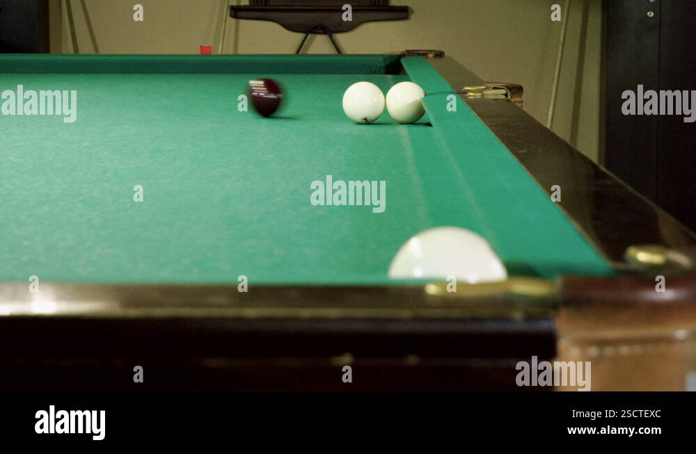 Men playing billiards, hitting balls with cue into pockets on billiard ...