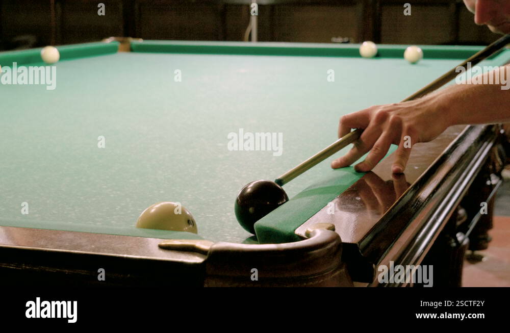 Men playing billiards, hitting balls with cue into pockets on billiard ...