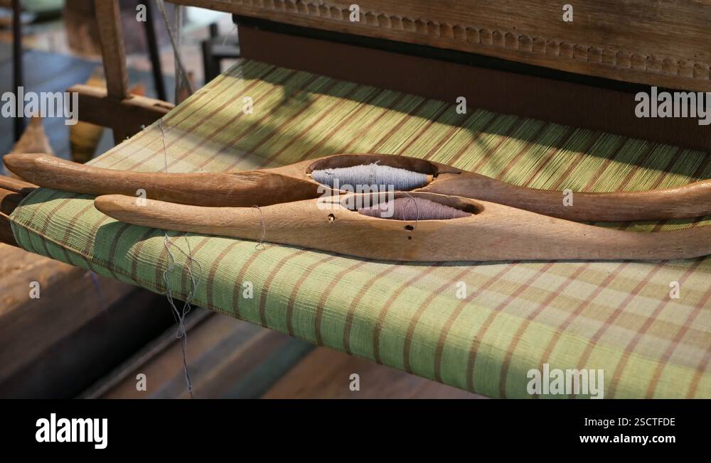 Threads on old loom. Wooden shuttles with natural threads placed on ...