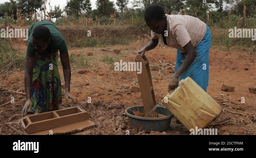 Women make Bricks, pressing mud mixture into an open timber frame ...