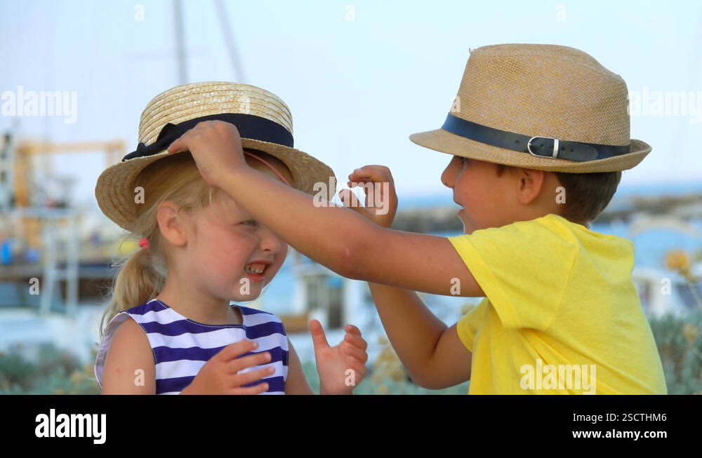 Little boy helps to dress a little girl's hat Stock Video Footage - Alamy