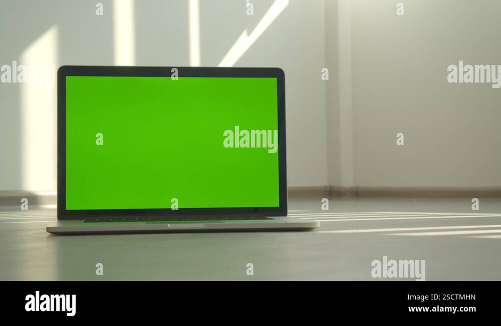 Closeup shoot of laptop with green screen laying on the table in the ...