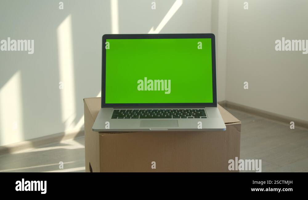 Closeup shoot of laptop with green screen laying on the box in the ...