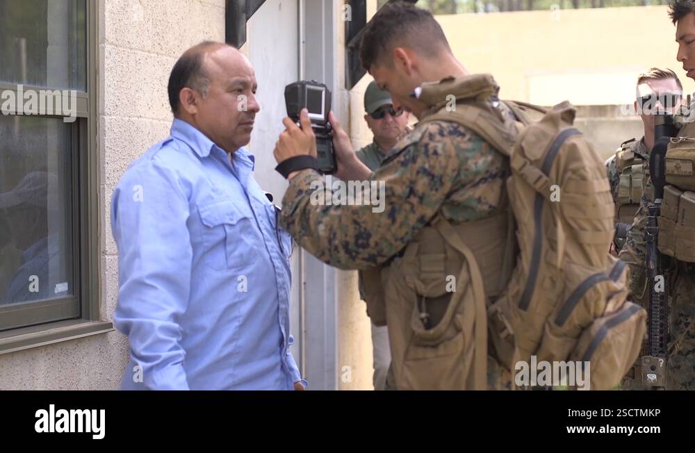Law Enforcement Marine using biometric reader to take photograph of ...