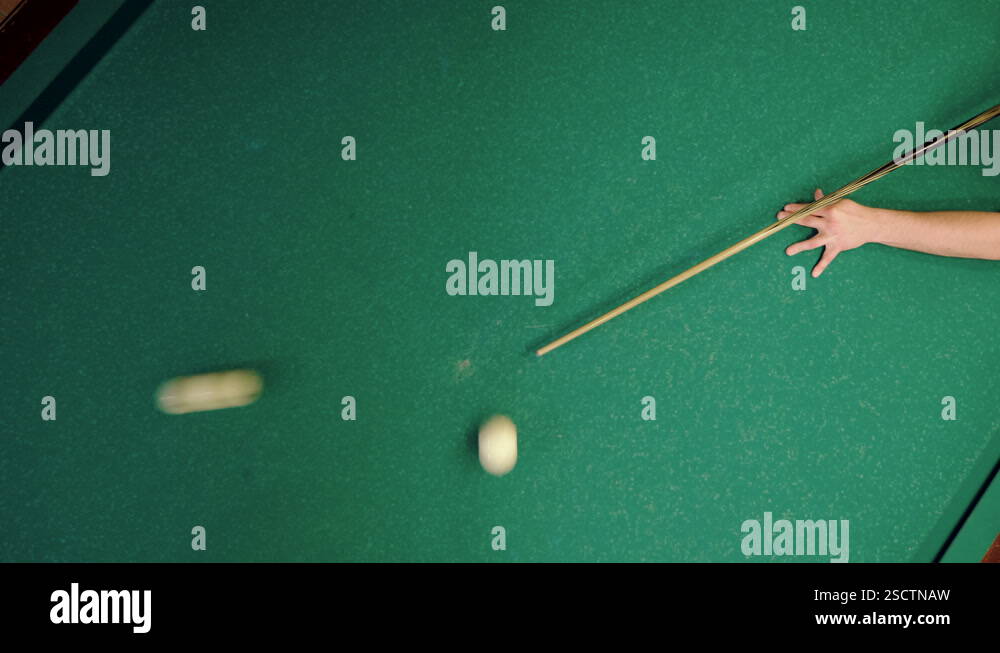 Man playing billiards, hitting balls with cue into pockets on billiard ...