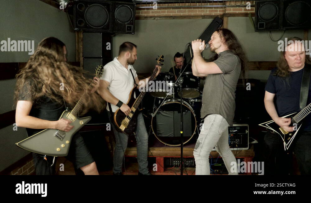 Musical metal band. Group of musicians playing rock music on stage. 4K ...