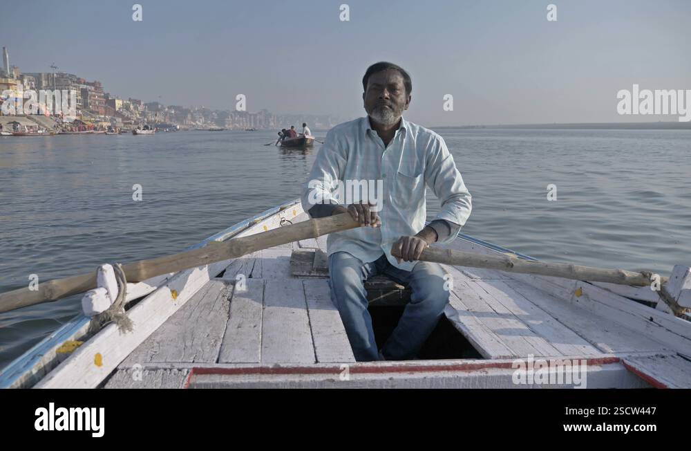 An Indian boatman rowing a boat in the Ganges in Varanasi, India Stock ...