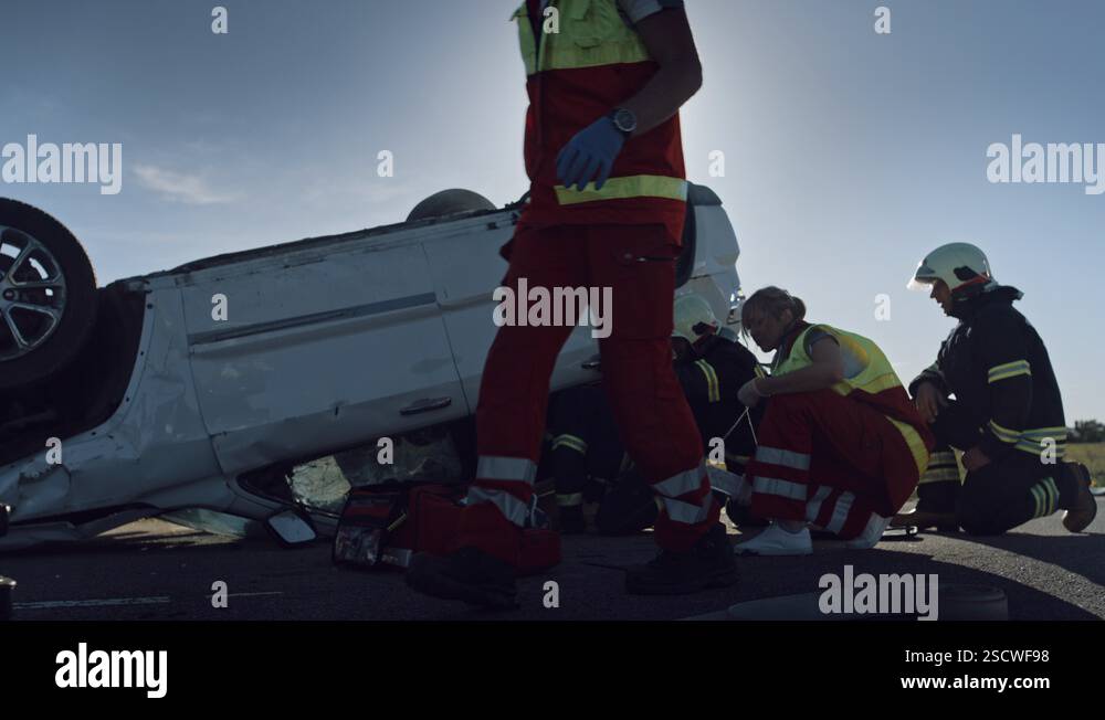 On the Car Crash Traffic Accident Scene: Paramedics Giving First Aid ...