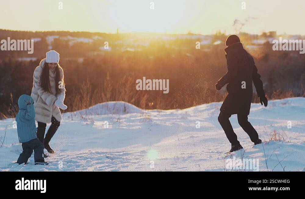 long haired lady and toddler son throw white snow to man Stock Video ...