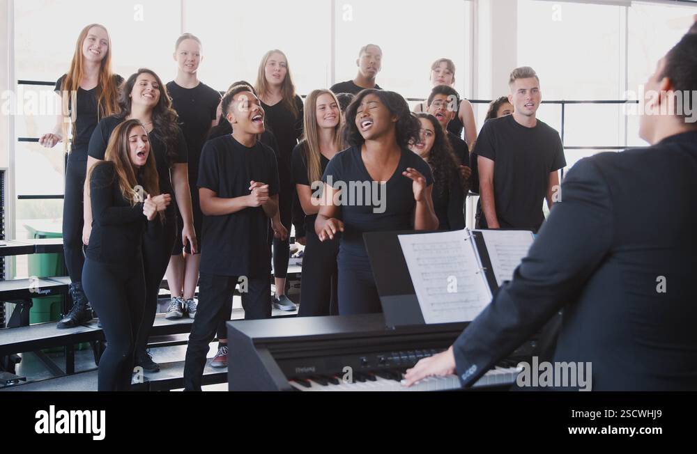 Male And Female Students Singing In Choir With Teacher At Performing ...