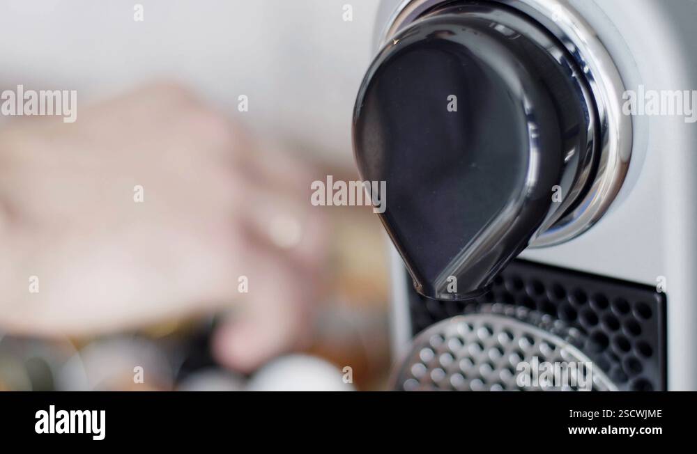 Closeup view of black compact coffee machine spout ready to pour coffee ...