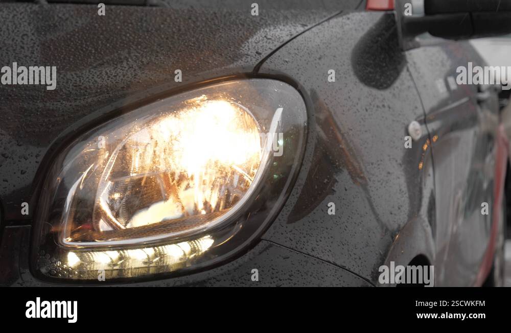Closeup black modern car in empty street with blinking headlights on ...