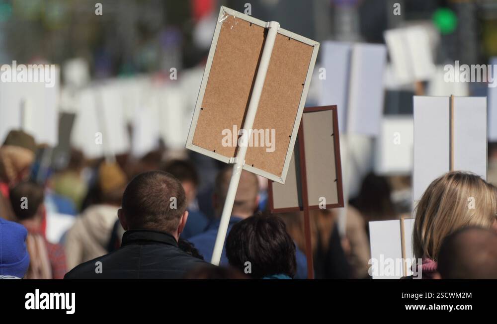 Crowd man walking down street France with banners defending their ...