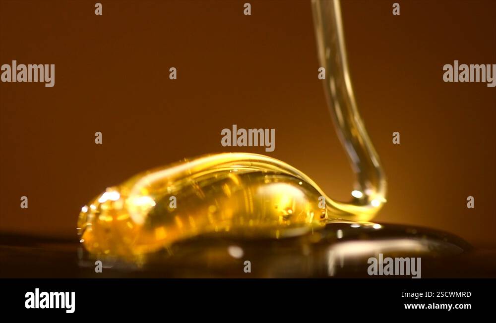 Honey. Liquid thick honey dripping over dark background, flowing syrup ...