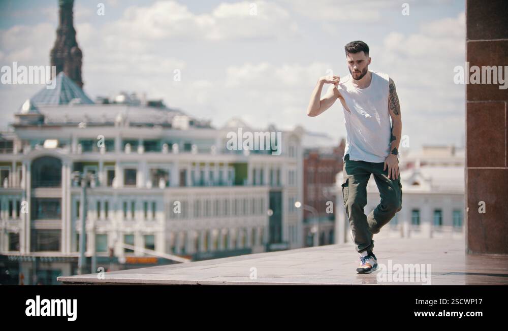 Young stylish man freestyle dancing on the stand - centre of the city ...