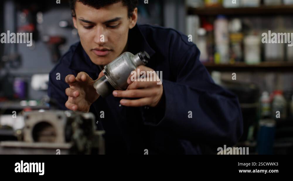 4K Cheerful young mechanic in garage workshop learning to rebuild ...