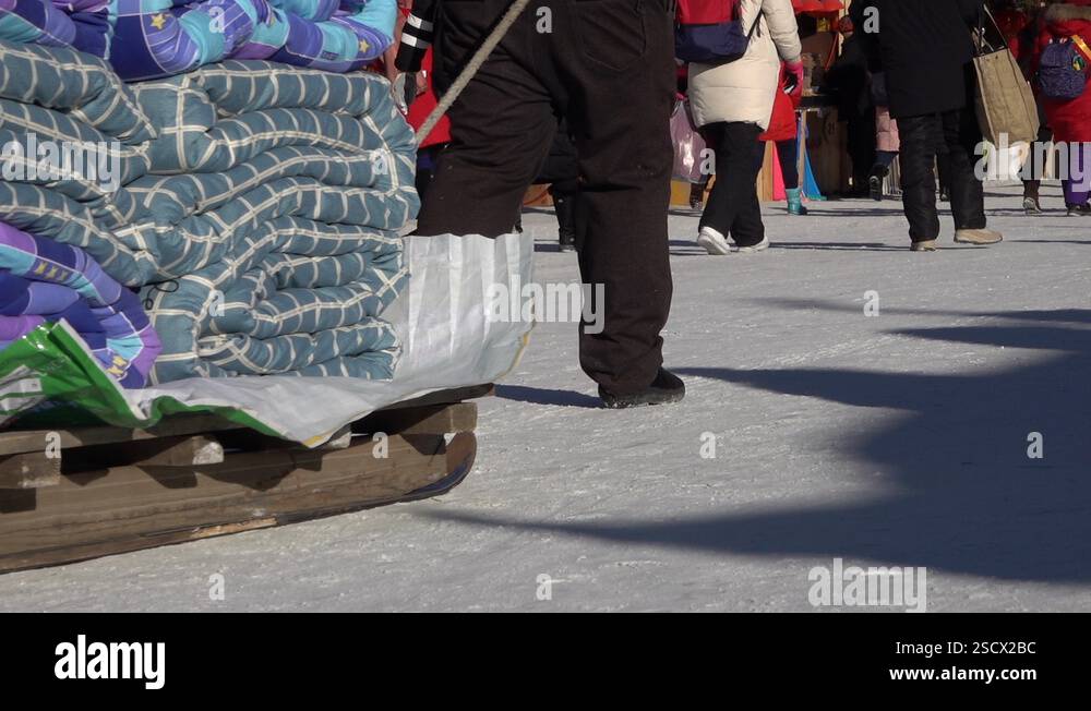 Close-up blankets transported on improved sled on snow in Chinese town ...