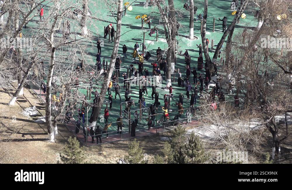 High angle view of group of Tibetans exercising in public park in Lhasa ...