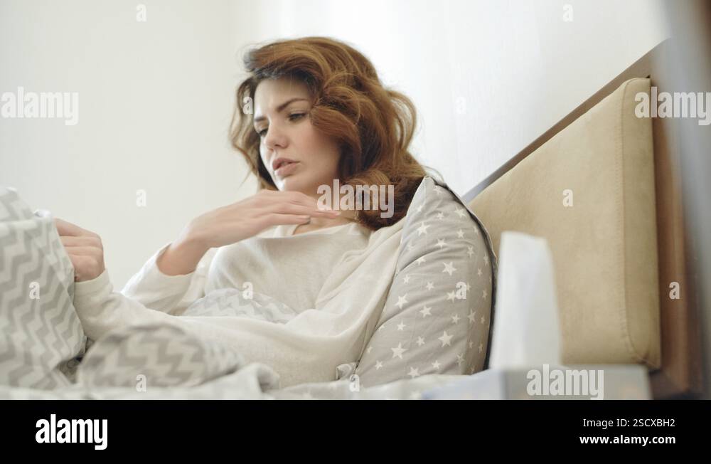 Pretty woman having cough lying in bed. Sick woman getting throat cold ...