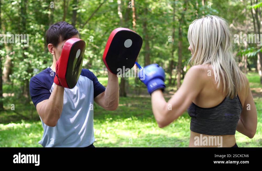 A woman with a coach is learning boxing, slow motion. Woman boxing in ...