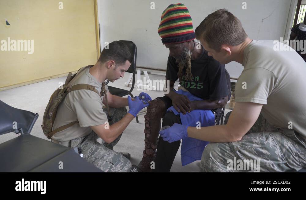 Military medic injecting syringe into patients diseased leg in clinic ...