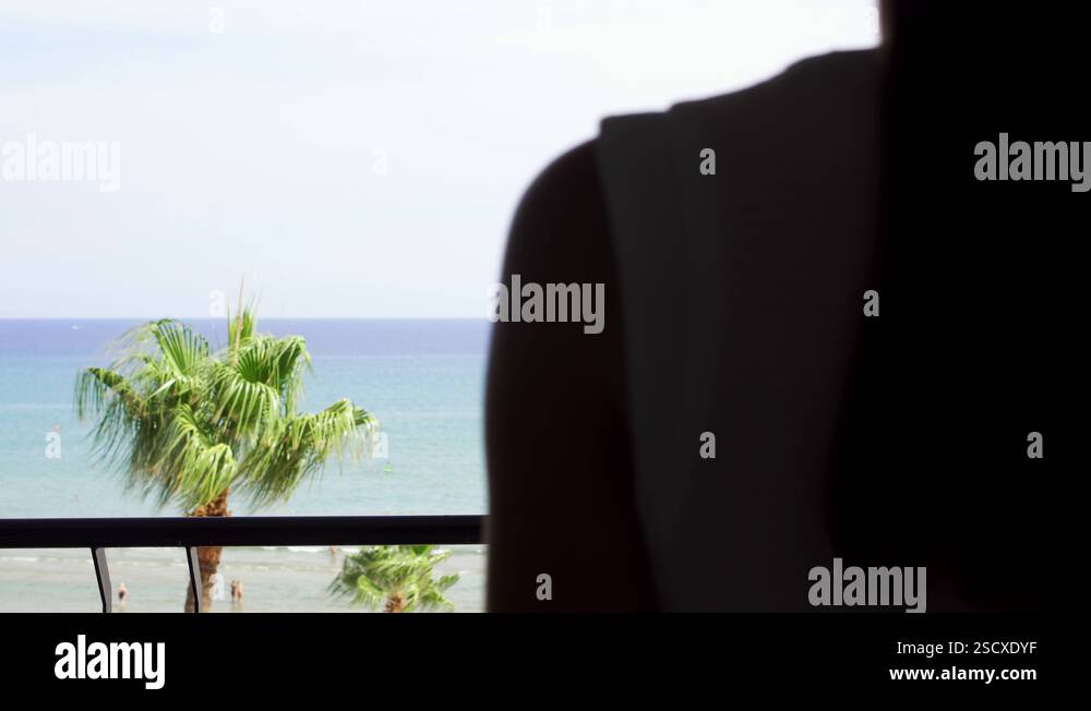 Woman go out onto balcony and enjoy view from terrace. Female on ...
