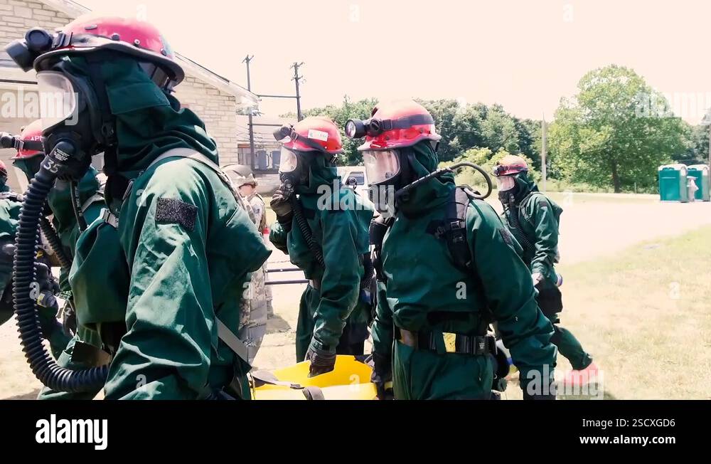 Soldiers wearing CBRN protective suits carrying casualty on rescue ...
