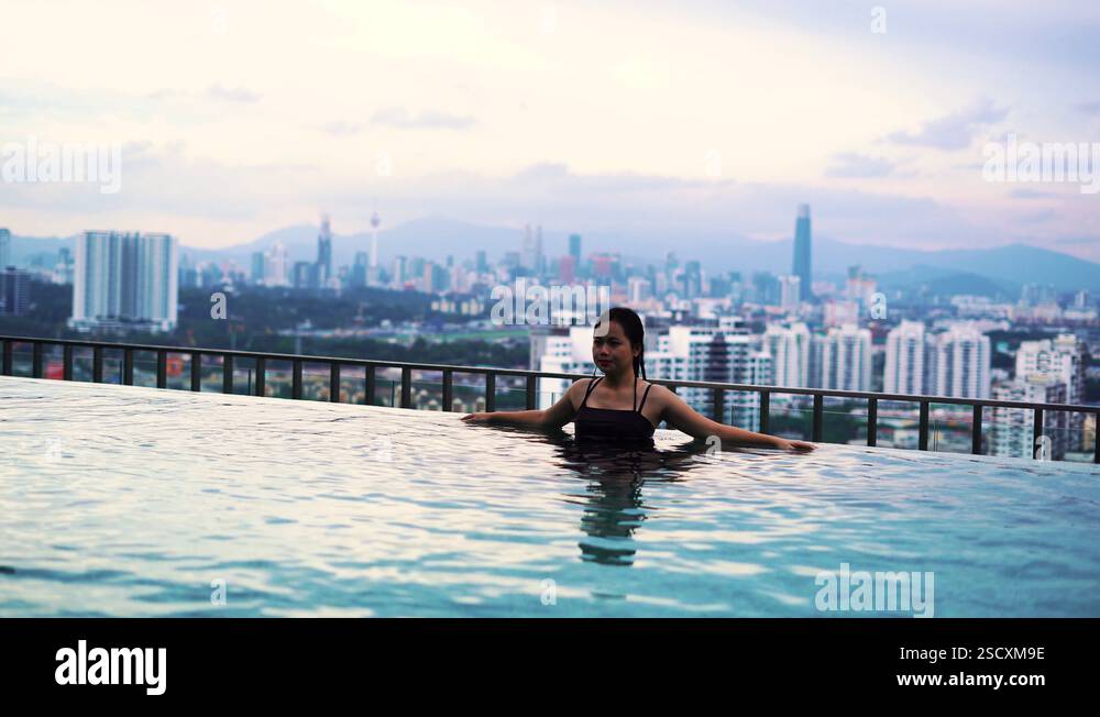 Asian woman in bikini and bun enjoying Summer holiday at swimming pool ...