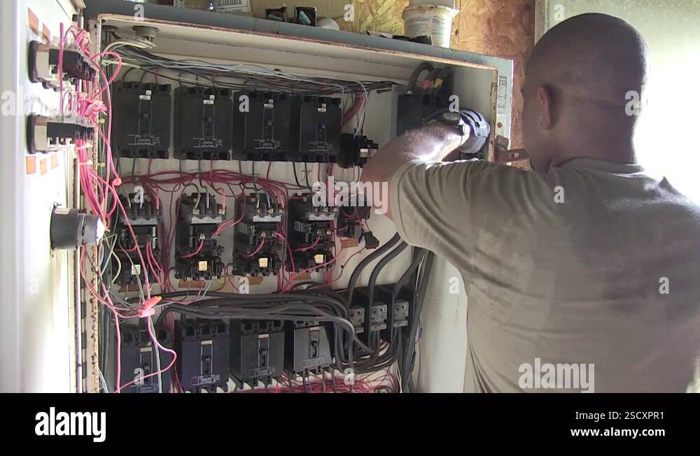 Soldier adjusting lever on control box in electrical circuit cupboard ...