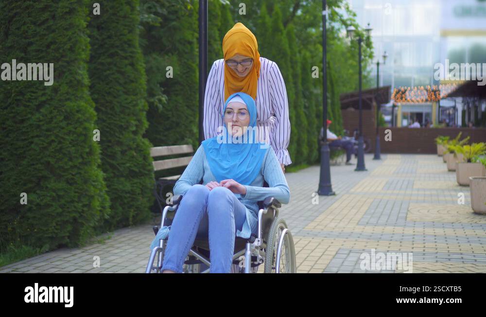 young muslim disabled in a traditional scarf and glasses in a ...