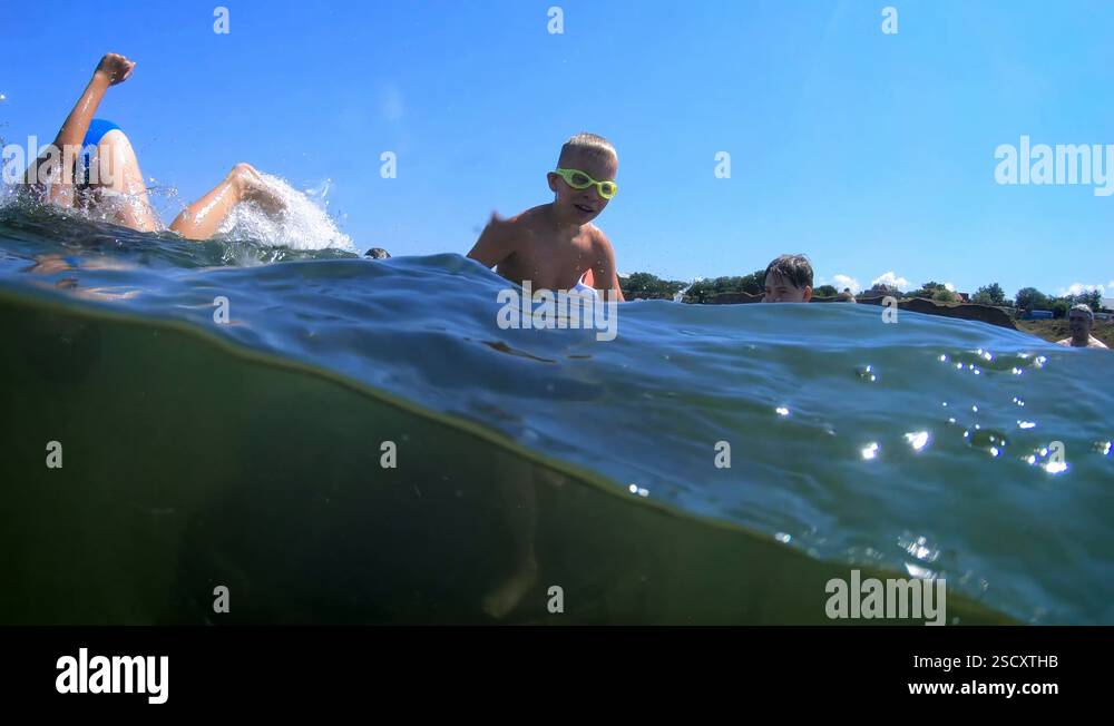 Young Handsome Boy Jumping to the Sea. Children jump into the sea of ...