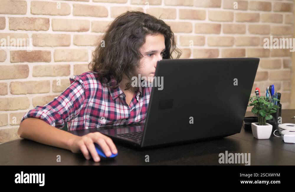 Working on a laptop computer, typing on a keyboard, modern teenager. A ...