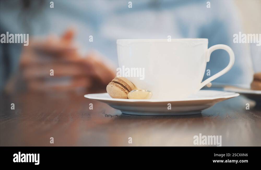 Big plan cup of cappuccino on the table in the cafe. During this girl ...