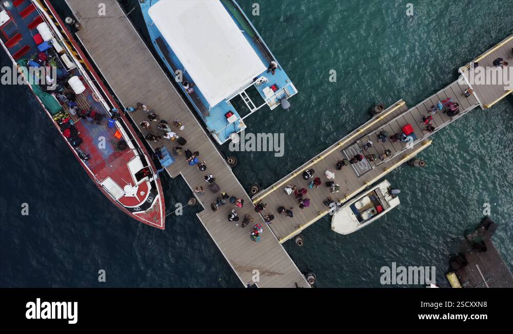 Top aerial view of wooden pier with tourists going on boat board.Gili ...