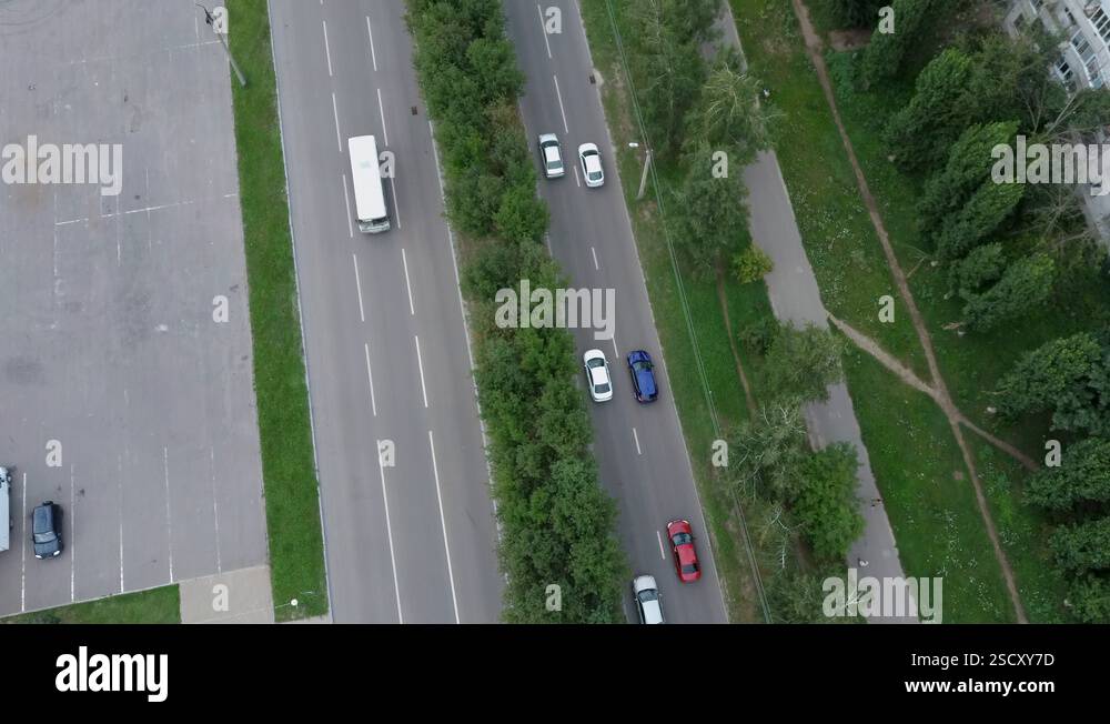 Cars are moving on the road in the city, two-way traffic. Aerial view ...