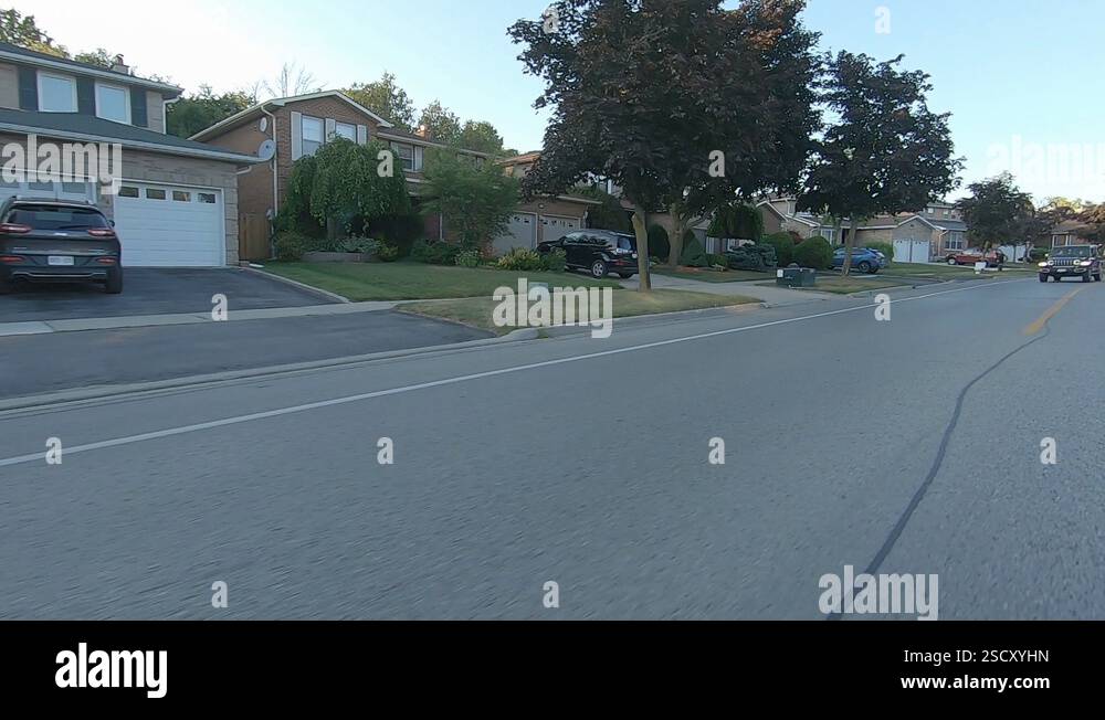 Driving in suburban residential area with streets and homes near ...