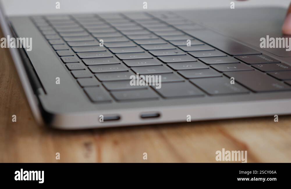 Male hands use trackpad and type on the keyboard of laptop, personal ...