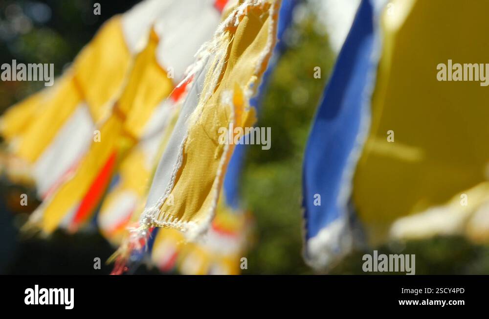 Buddhist prayer flags swaying in the wind in the rays of the rising sun ...