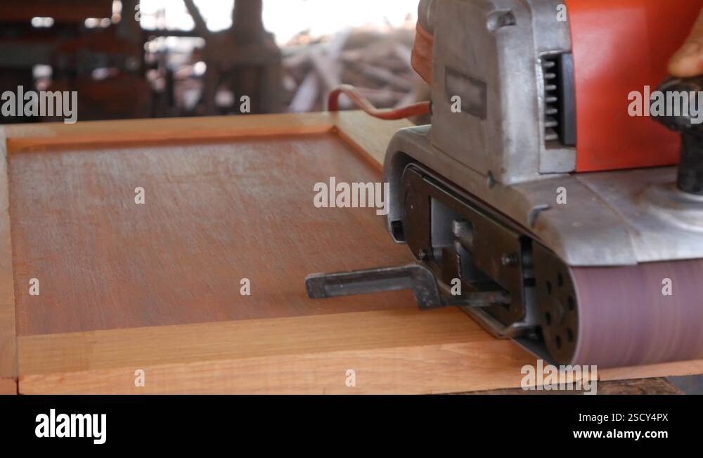 Craftsman using sander machine while carpentry work in workshop. Worker ...