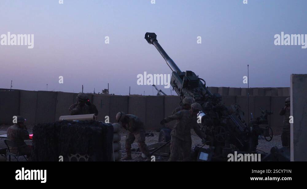 U.S. Army soldiers fire M777 Howitzer at dusk towards enemy lines in ...