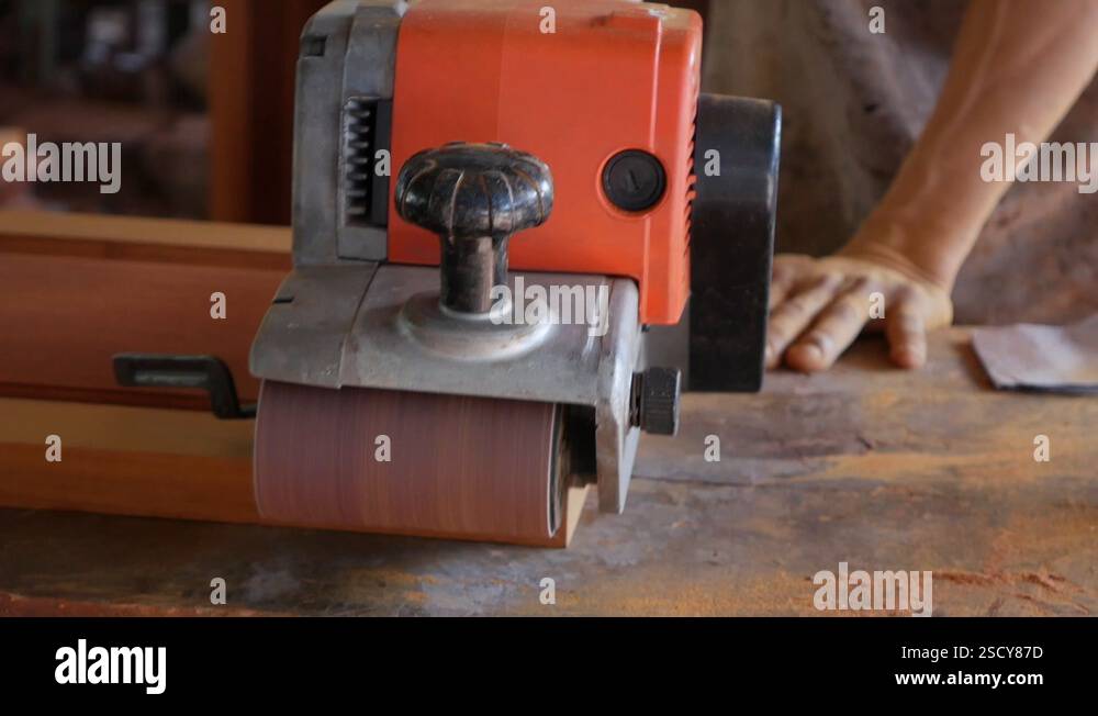 Craftsman using sander machine while carpentry work in workshop. Worker ...