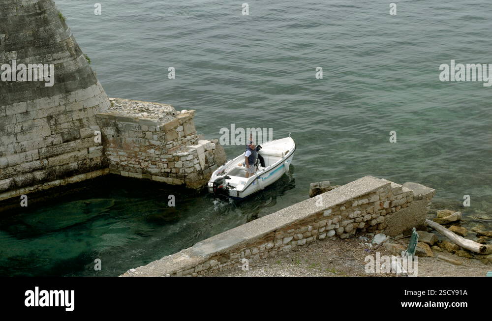 The boat sailing through the canal along the old fortress in Greece. 4K ...